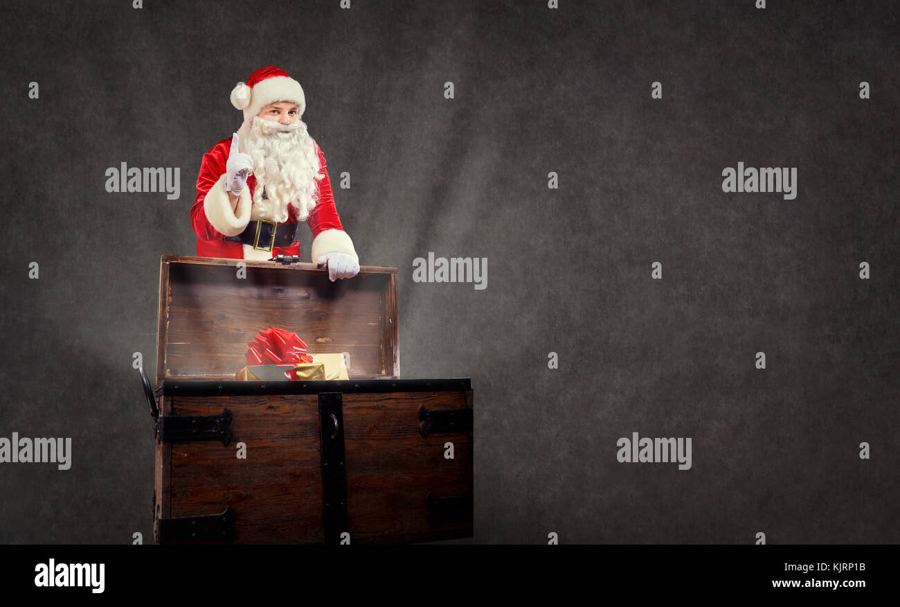 Santa Claus with a chest of gift on a copyspace background Stock Photo ...