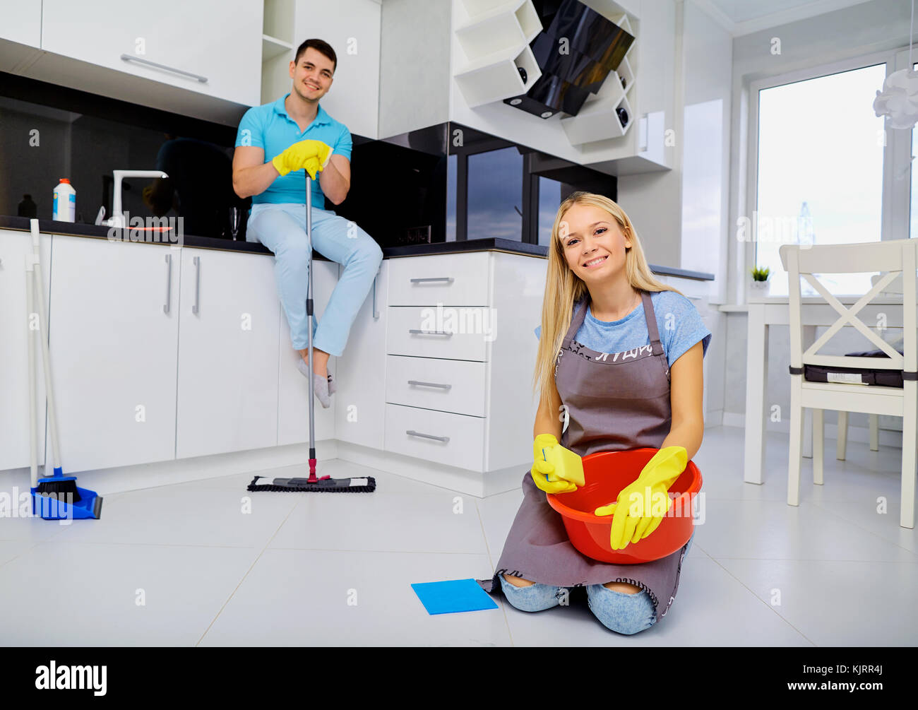 Young family couple doing cleaning in the kitchen Stock Photo - Alamy