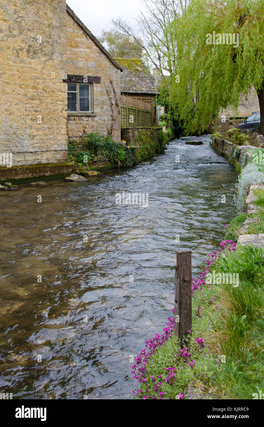 Stream passing houses in the rural village of Bourton on the Water in ...