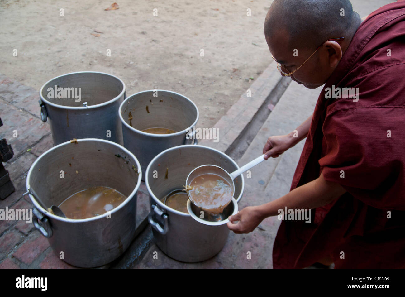 BUDDHIST MONKS HELPING THEMSELVES TO SOUP FROM A BIG POT AT A MONASTERY ...