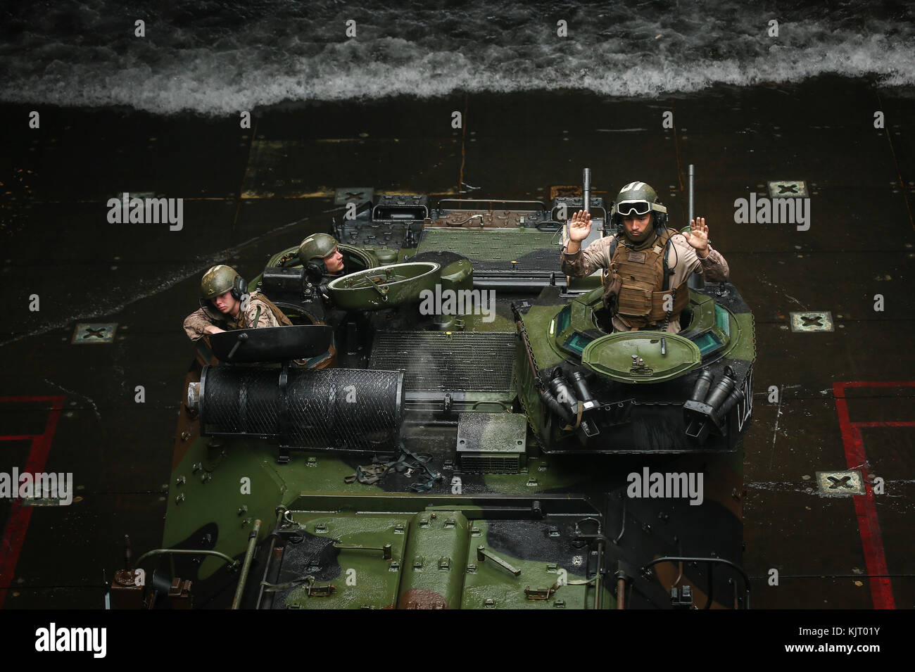 U.S. Marine Corps soldiers drive an amphibious assault vehicle onto the ...