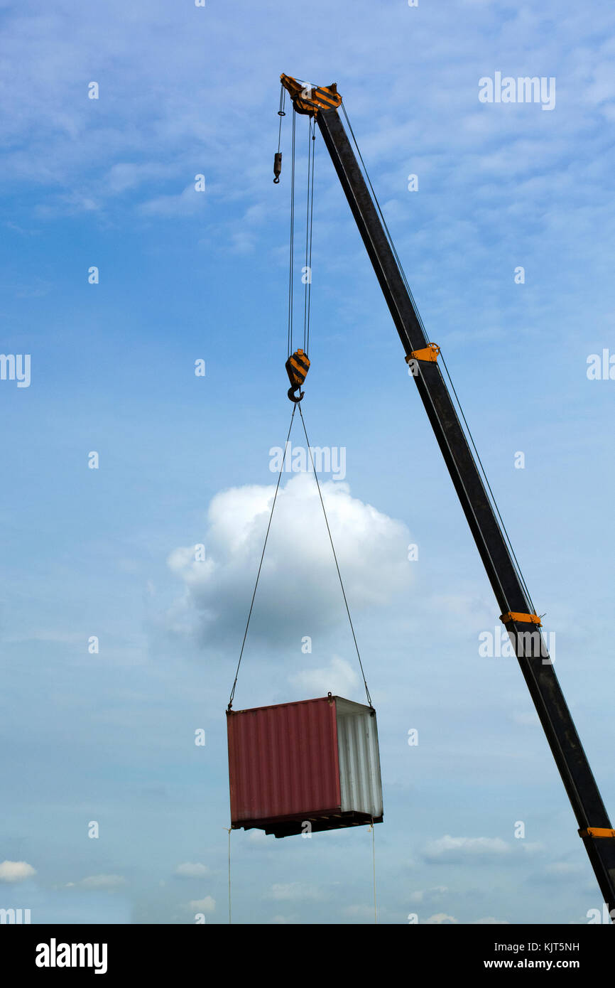 Crane lifting cutoff container moving in to the sky Stock Photo - Alamy