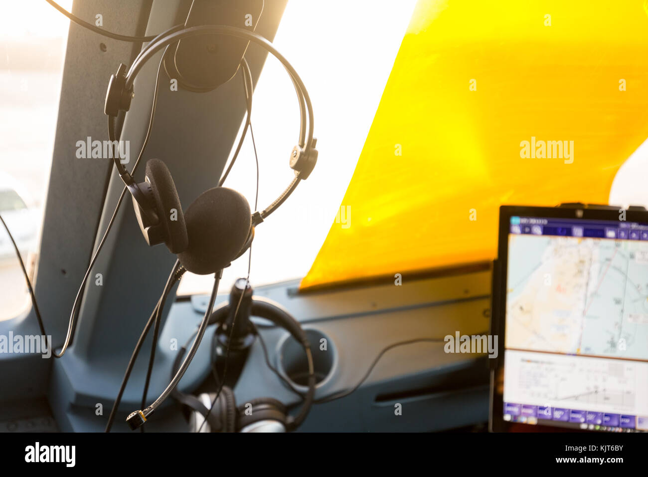 Hung headset in a cockpit of a commercial plane behind a sun blind ...