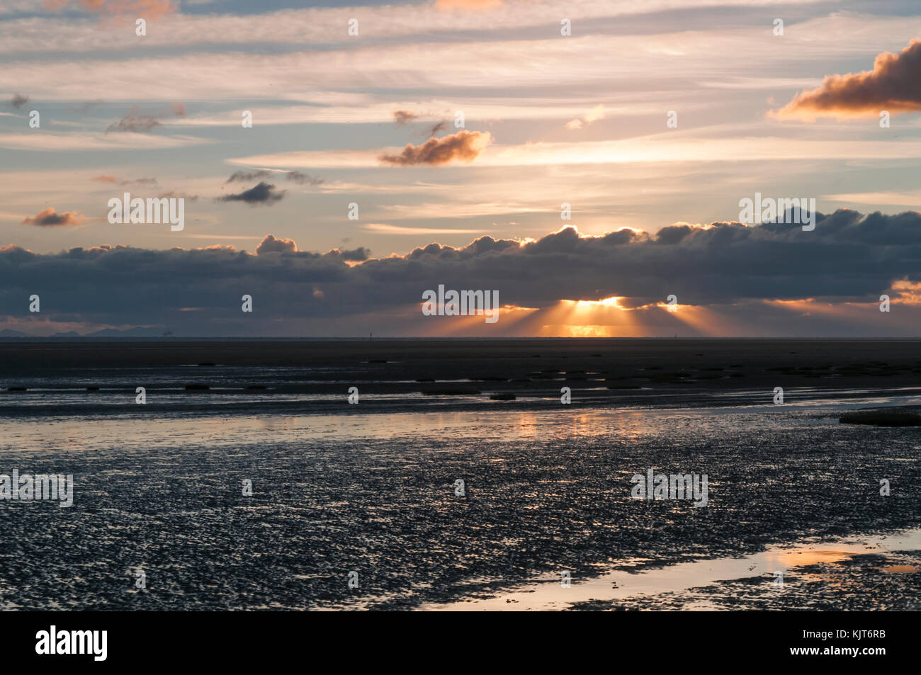Sunset over the beach expanse and water pools towards the Irish Sea ...