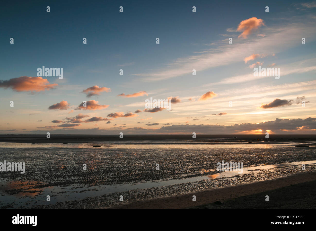 Sunset over the beach expanse and water pools towards the Irish Sea ...