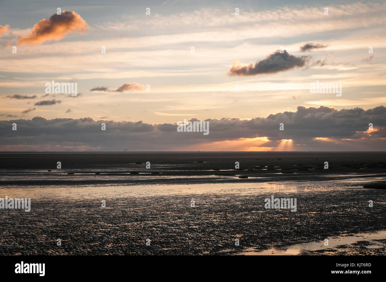 Sunset over the beach expanse and water pools towards the Irish Sea ...