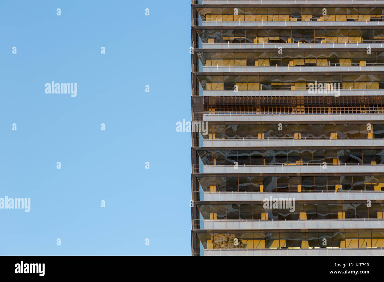 Modern facade of a multi story building next to blue, clear sky in ...