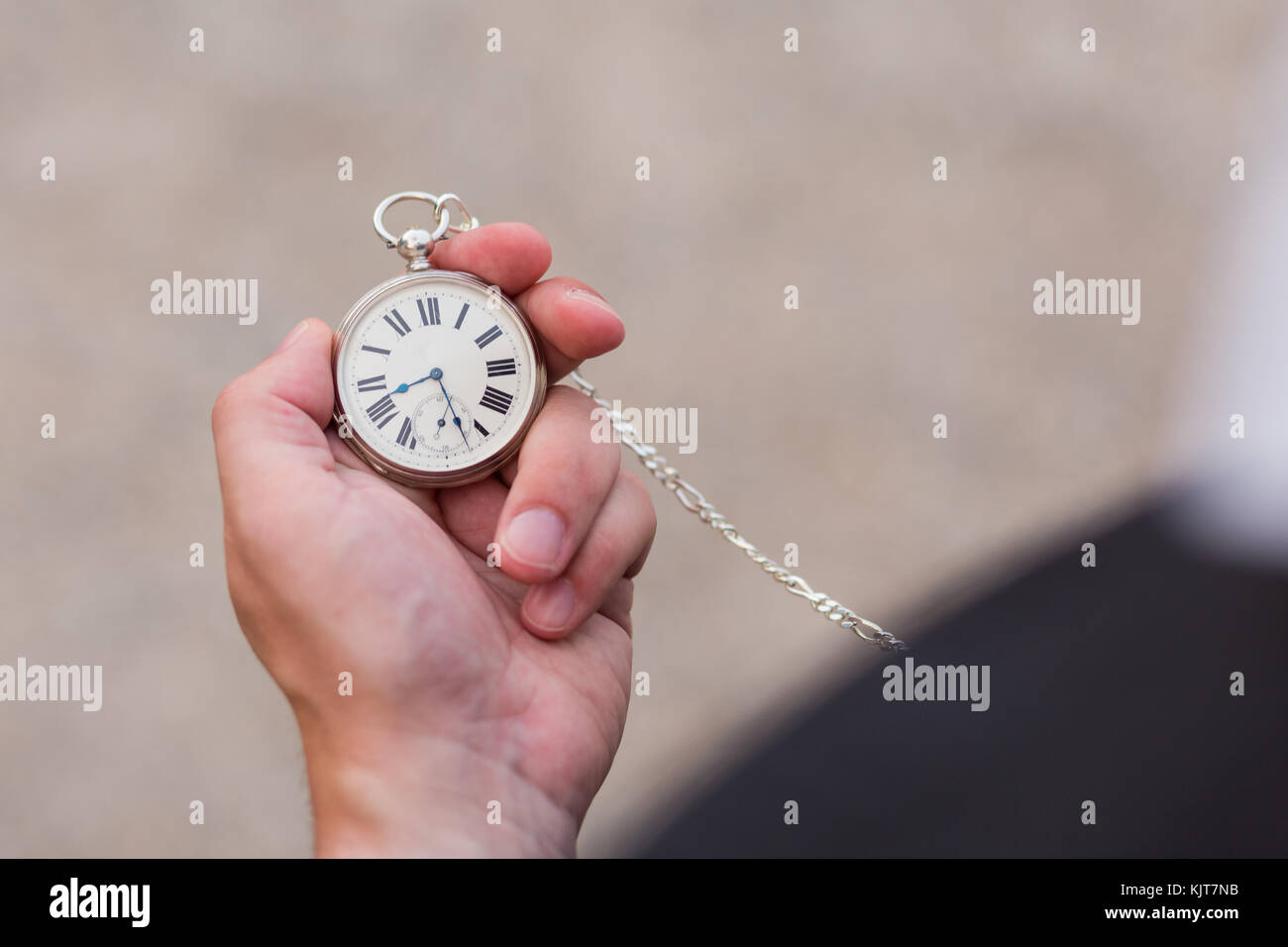 A man holding his inherited classic silver pocket watch with roman ...