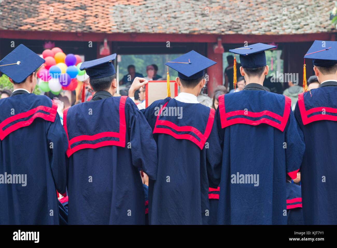 Graduation ceremony behind an asian dragon sculpture at the temple of ...