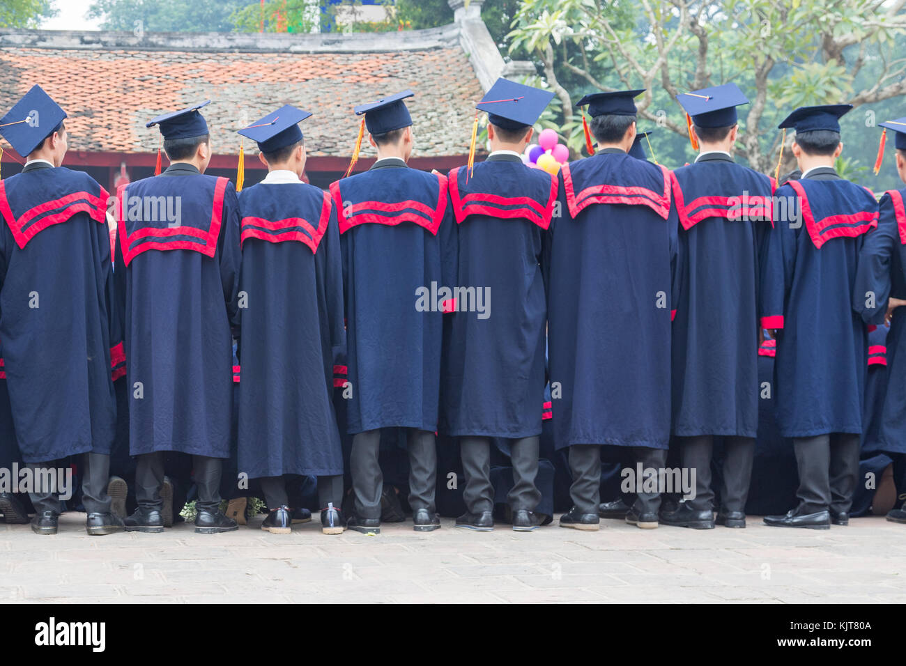 Graduation ceremony behind an asian dragon sculpture at the temple of ...
