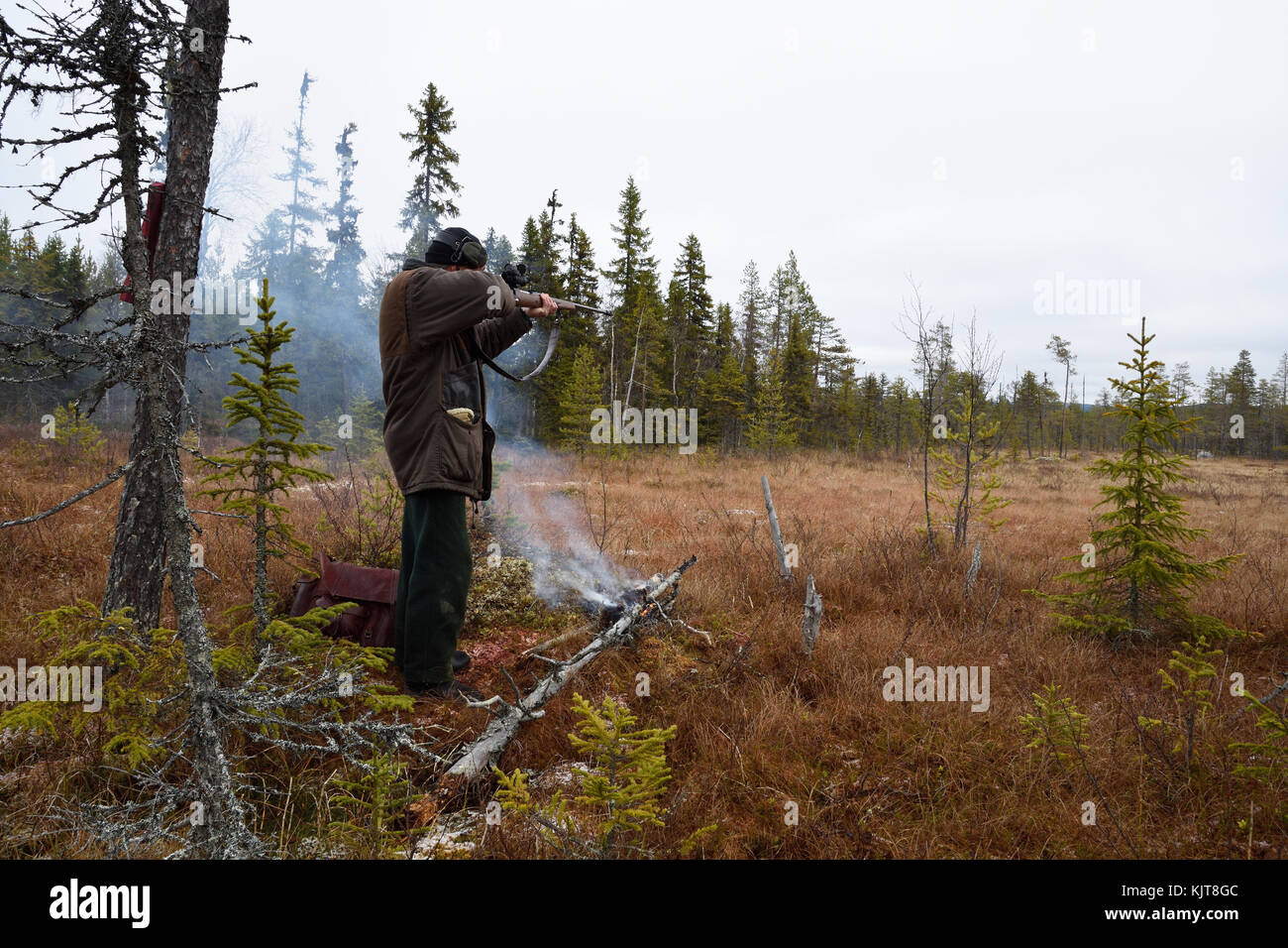 Moose hunter with a little fire standing and aiming, picture from the ...