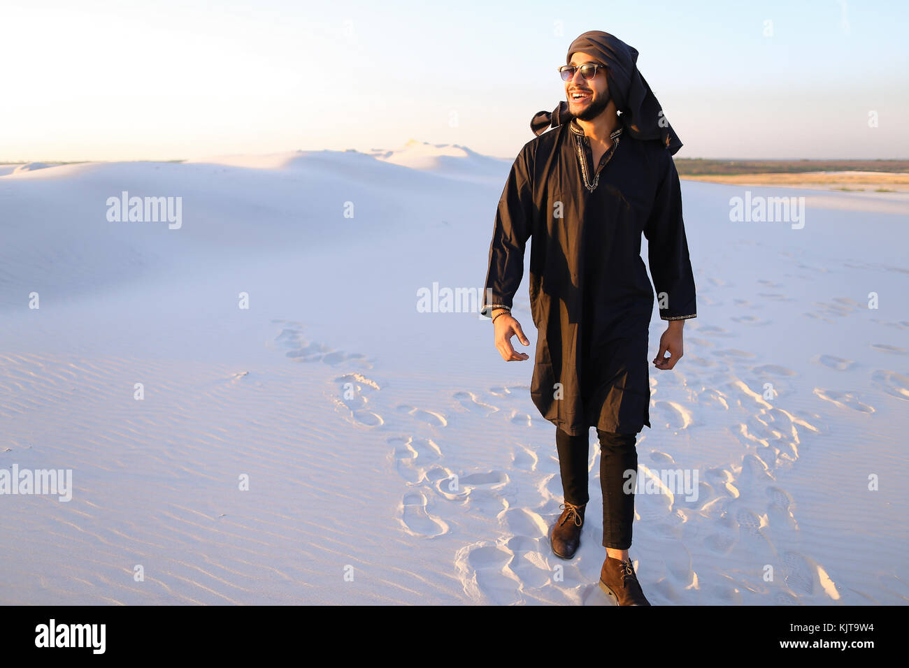 Happy fellow Arabian, walks through desert, smiles and enjoys li Stock ...