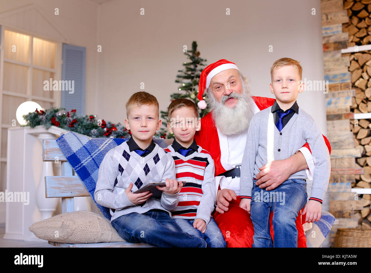 Father enjoys kids playing role of Santa Claus Stock Photo - Alamy