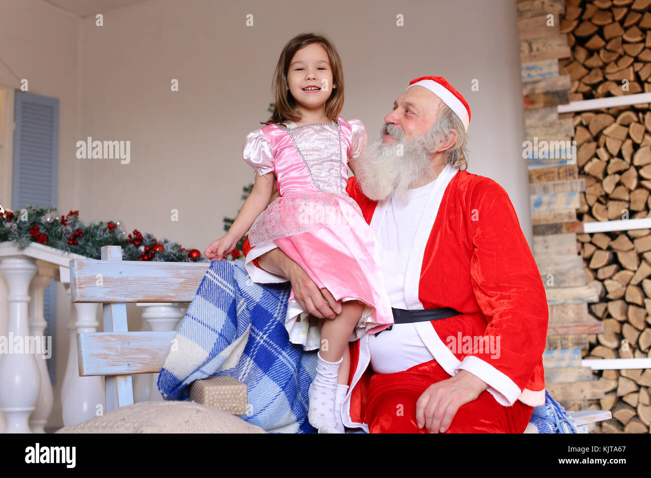 Grandfather playing Santa Claus role for granddaughter Stock Photo - Alamy