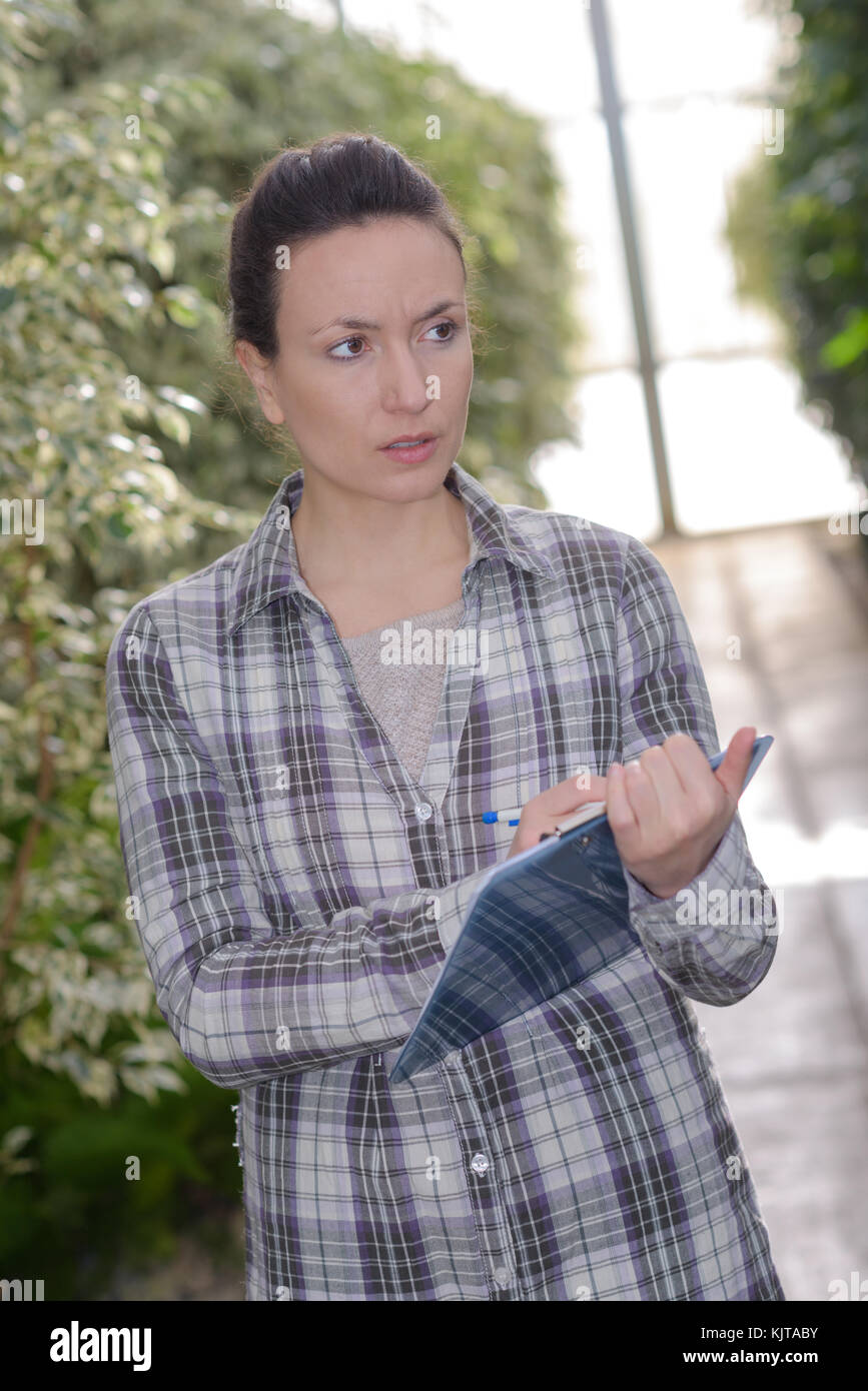 beautiful supervisor writing on clipboard at plant nursery Stock Photo ...