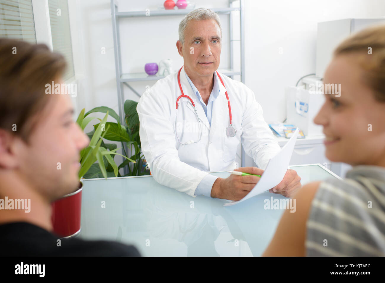 Doctor giving good news to young couple Stock Photo - Alamy