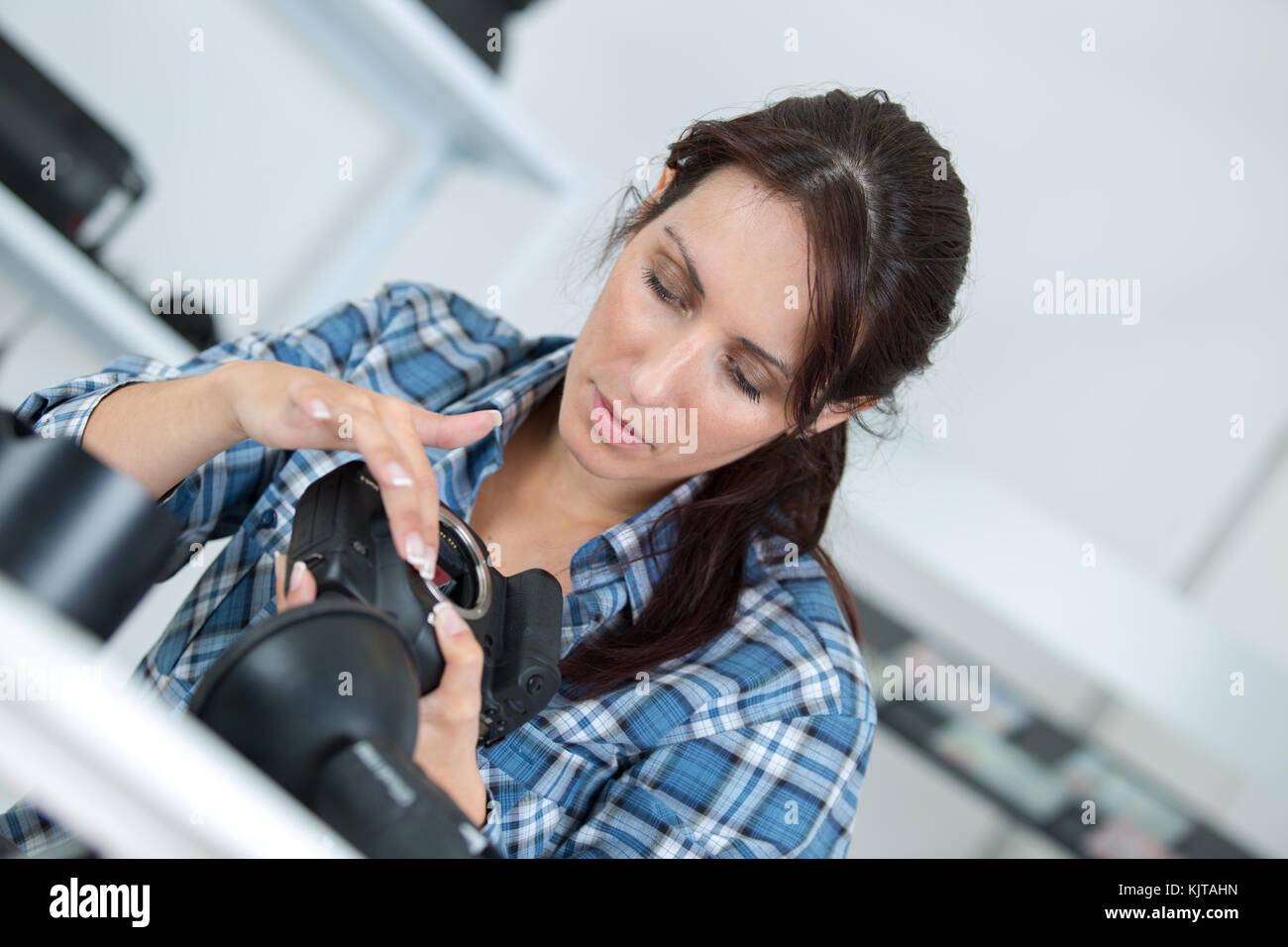 woman inspecting the lens of the camera Stock Photo - Alamy