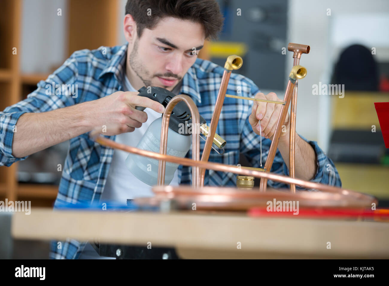 young worker using propane gas torch for soldering copper pipes Stock ...