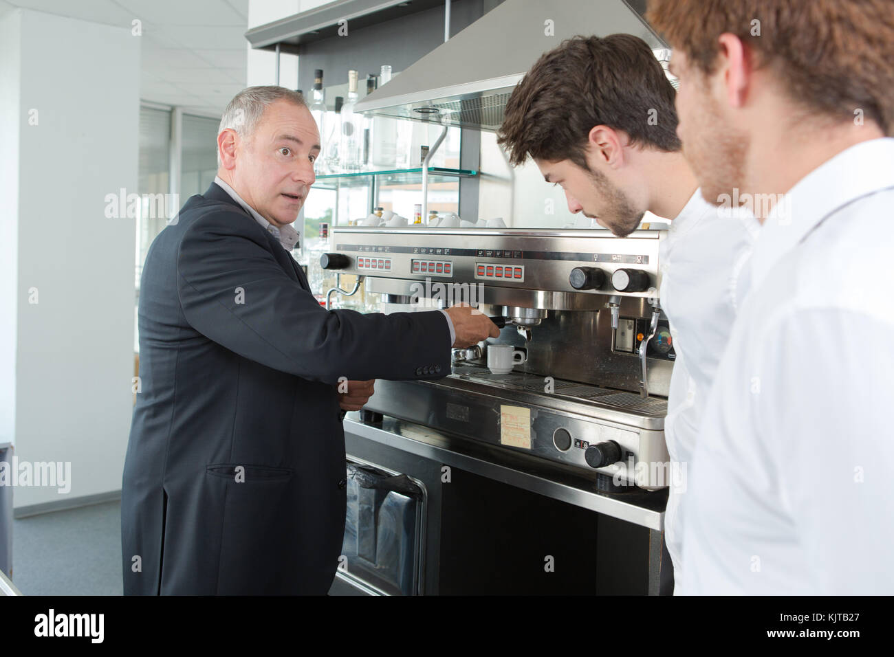 Young waiters learning how to use coffee machine Stock Photo - Alamy