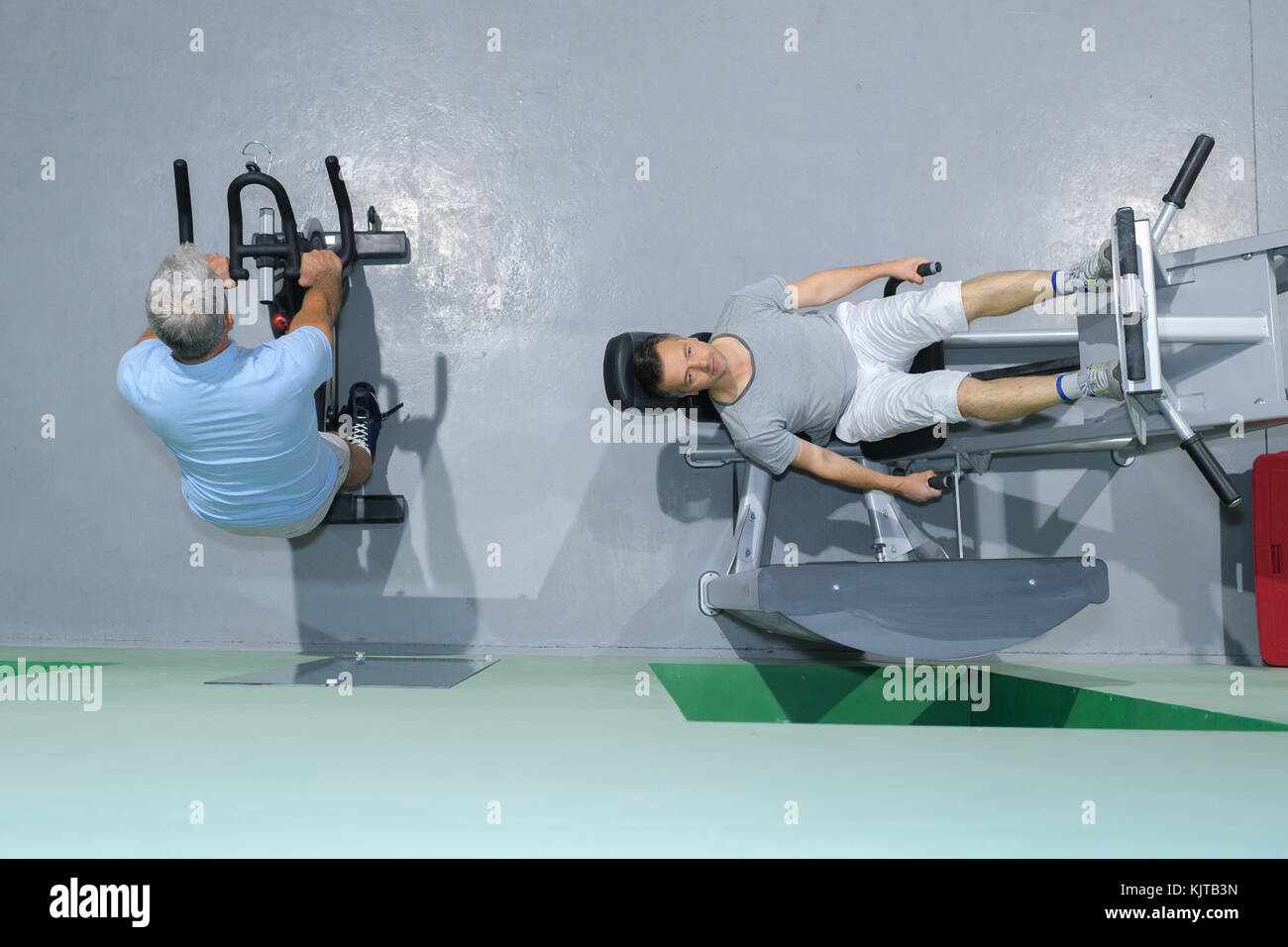downward view of two men on exercise machines Stock Photo - Alamy