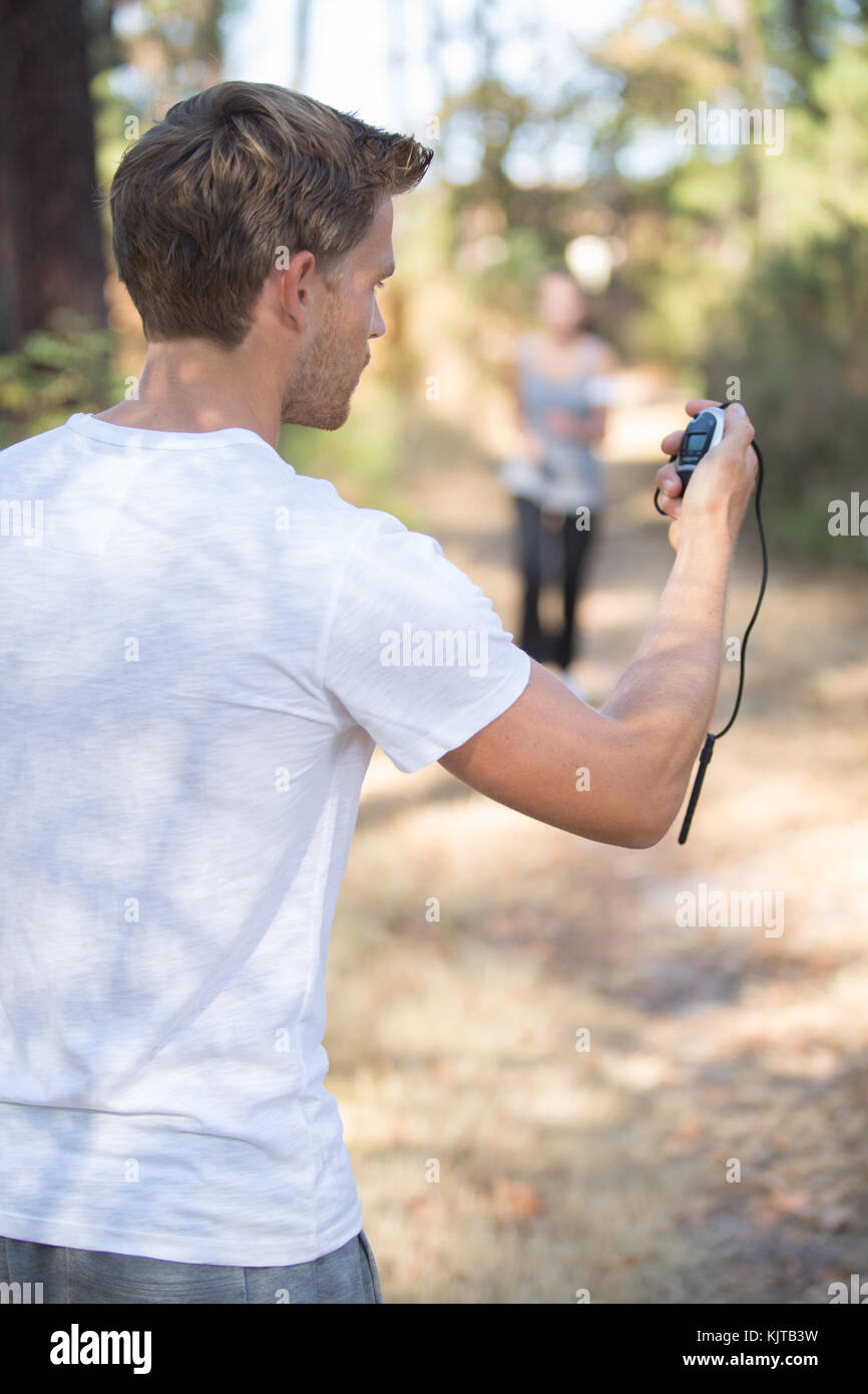 Man with stopwatch timing woman running Stock Photo - Alamy