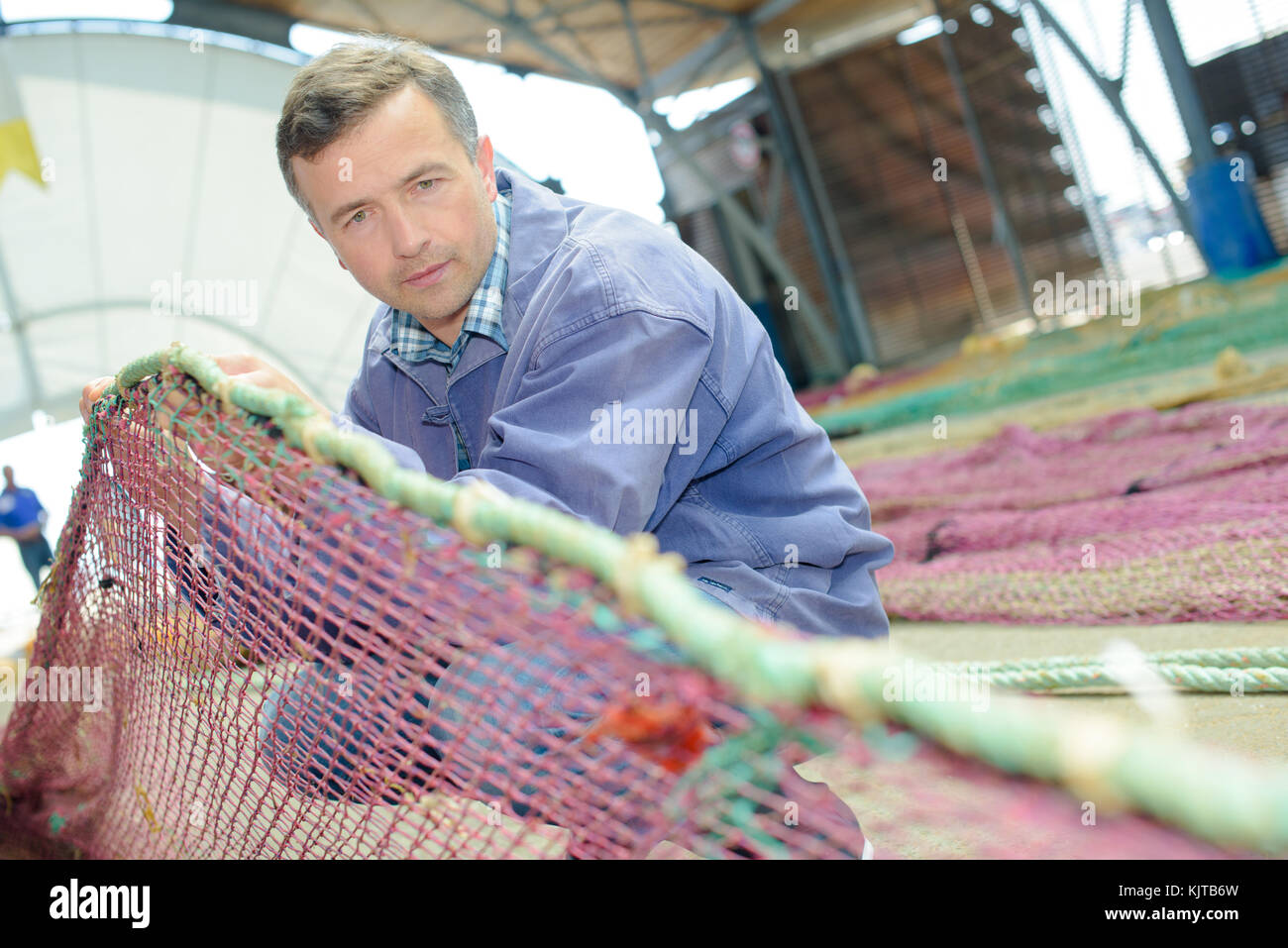fixing the fishing net Stock Photo - Alamy