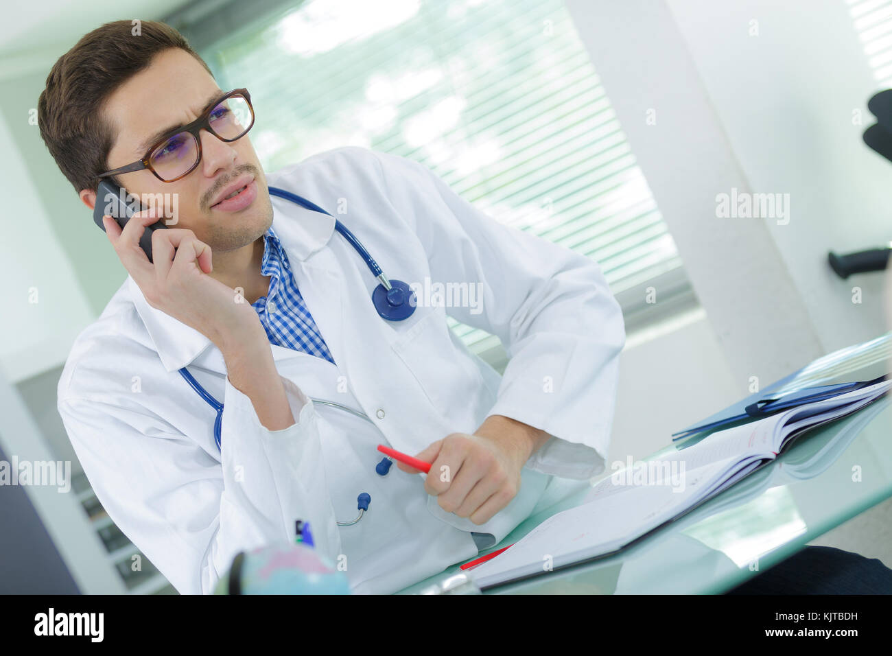 handsome young doctor talking on the phone at his office Stock Photo ...