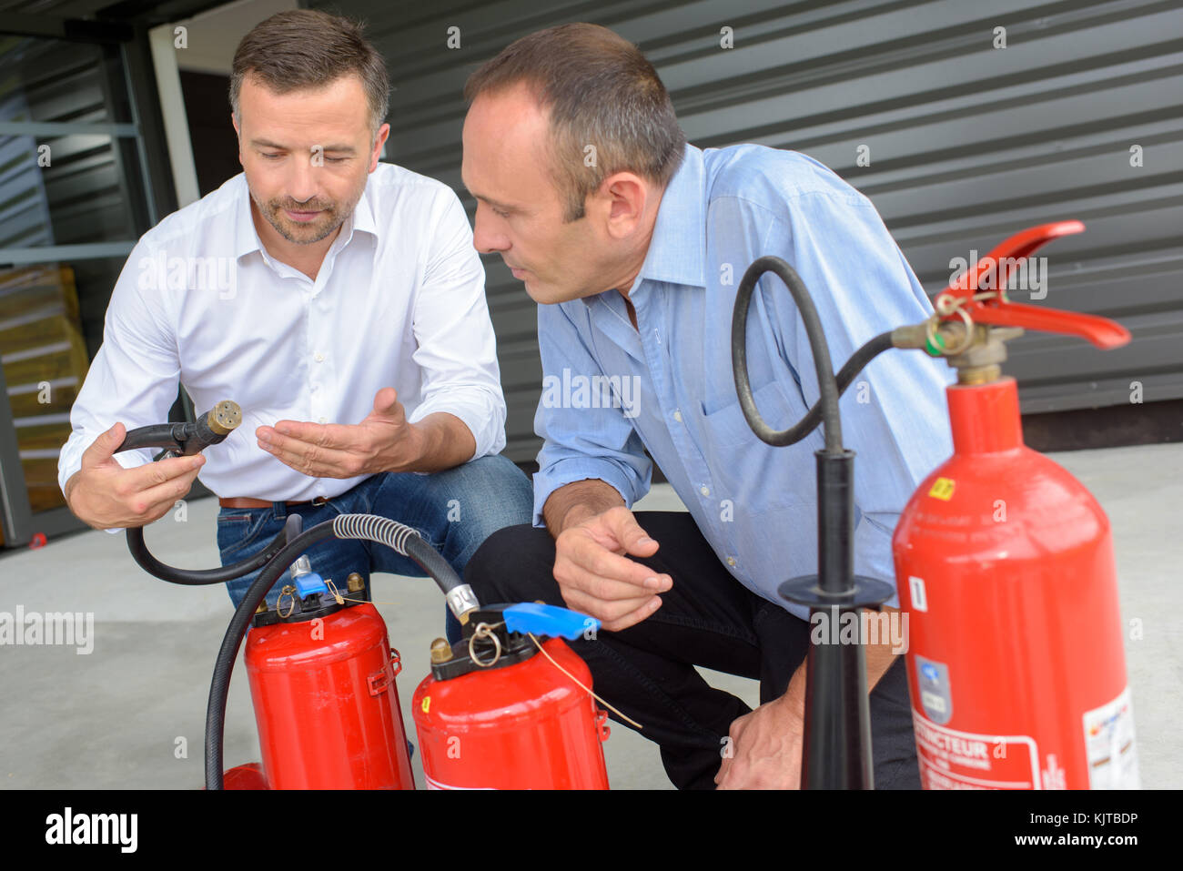 instructor explaining how to use fire extinguisher Stock Photo - Alamy