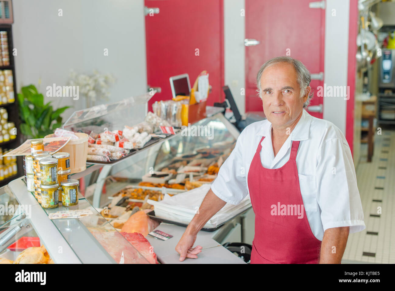 Man standing behind counter in deli Stock Photo - Alamy