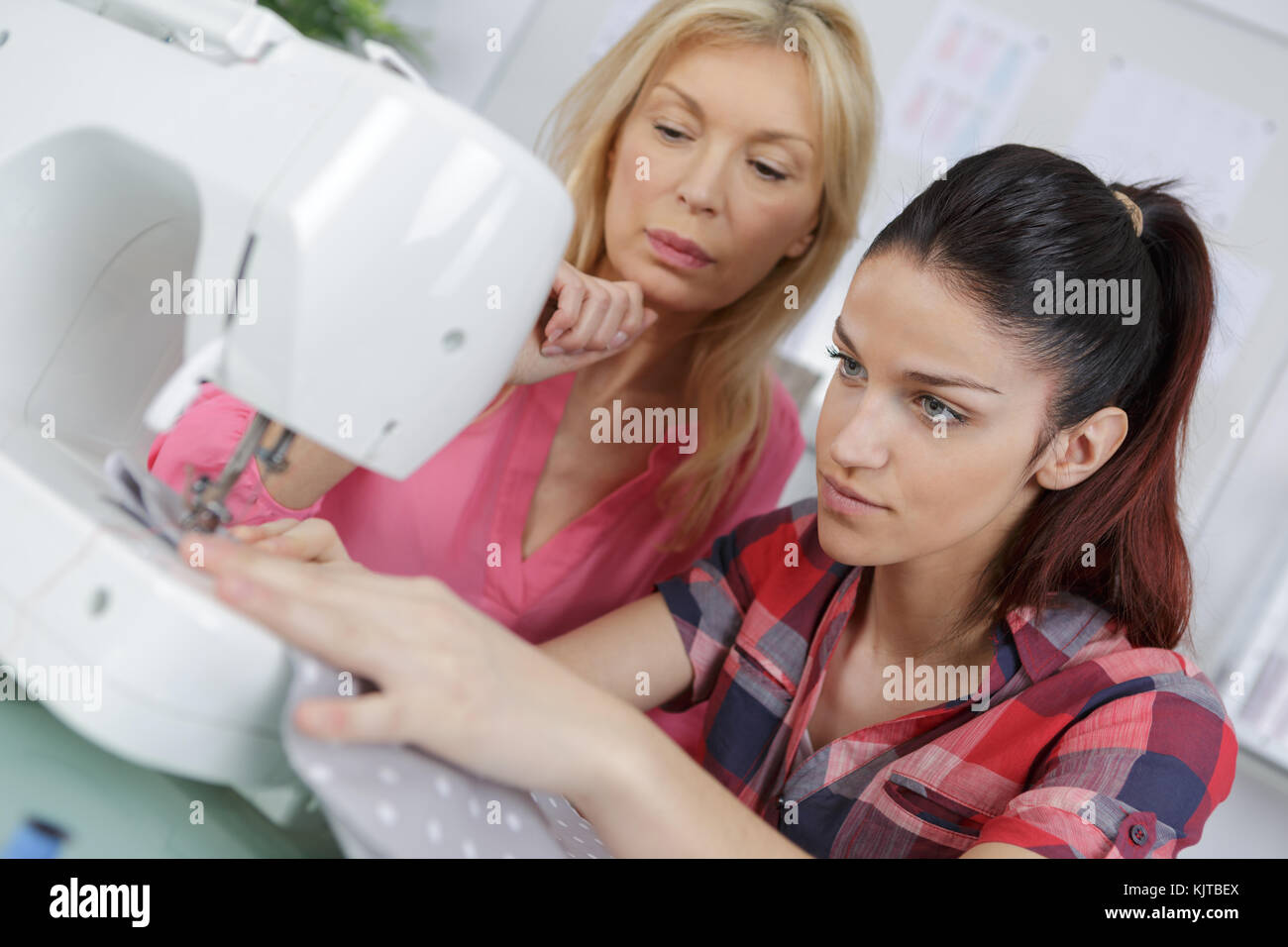 mother teaching daughter how to use a sewing machine Stock Photo - Alamy