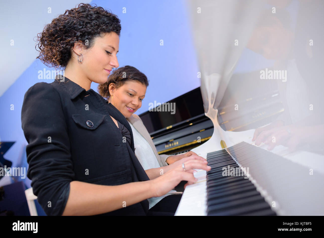 Women playing duet on piano Stock Photo - Alamy