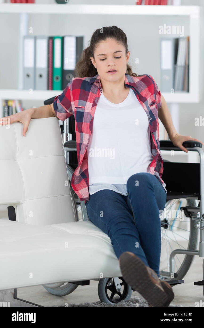 disabled woman trying to sit on sofa by herself Stock Photo - Alamy