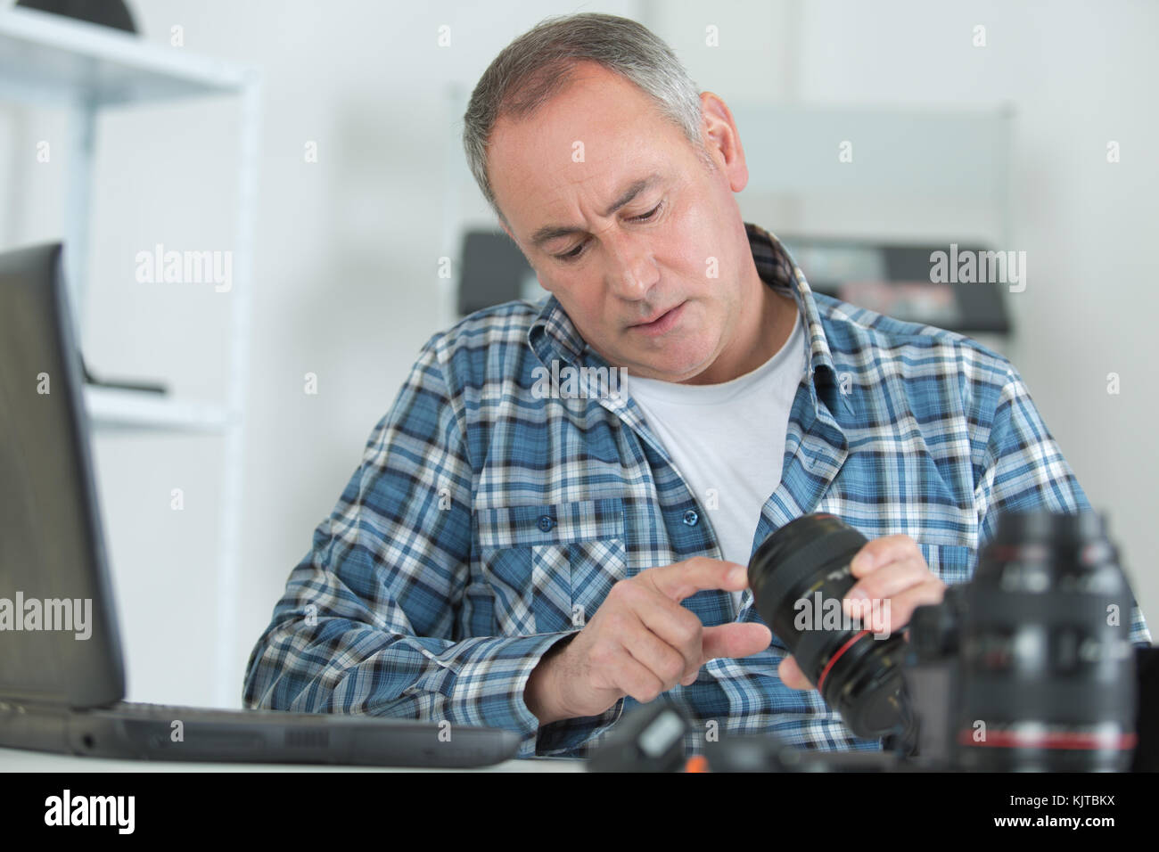 Man examining camera lens Stock Photo - Alamy