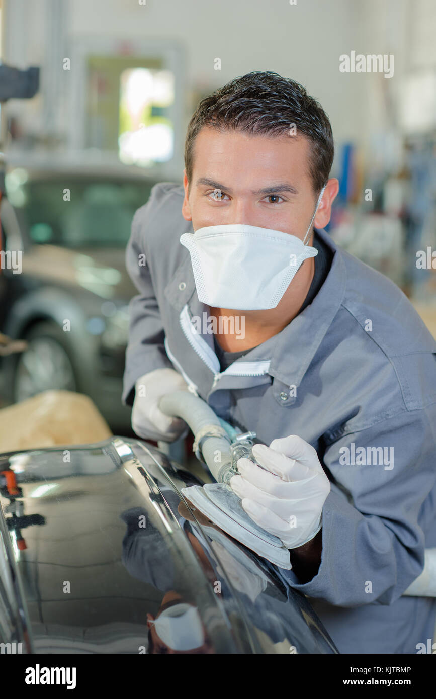 Young mechanic polishing a bodywork Stock Photo - Alamy