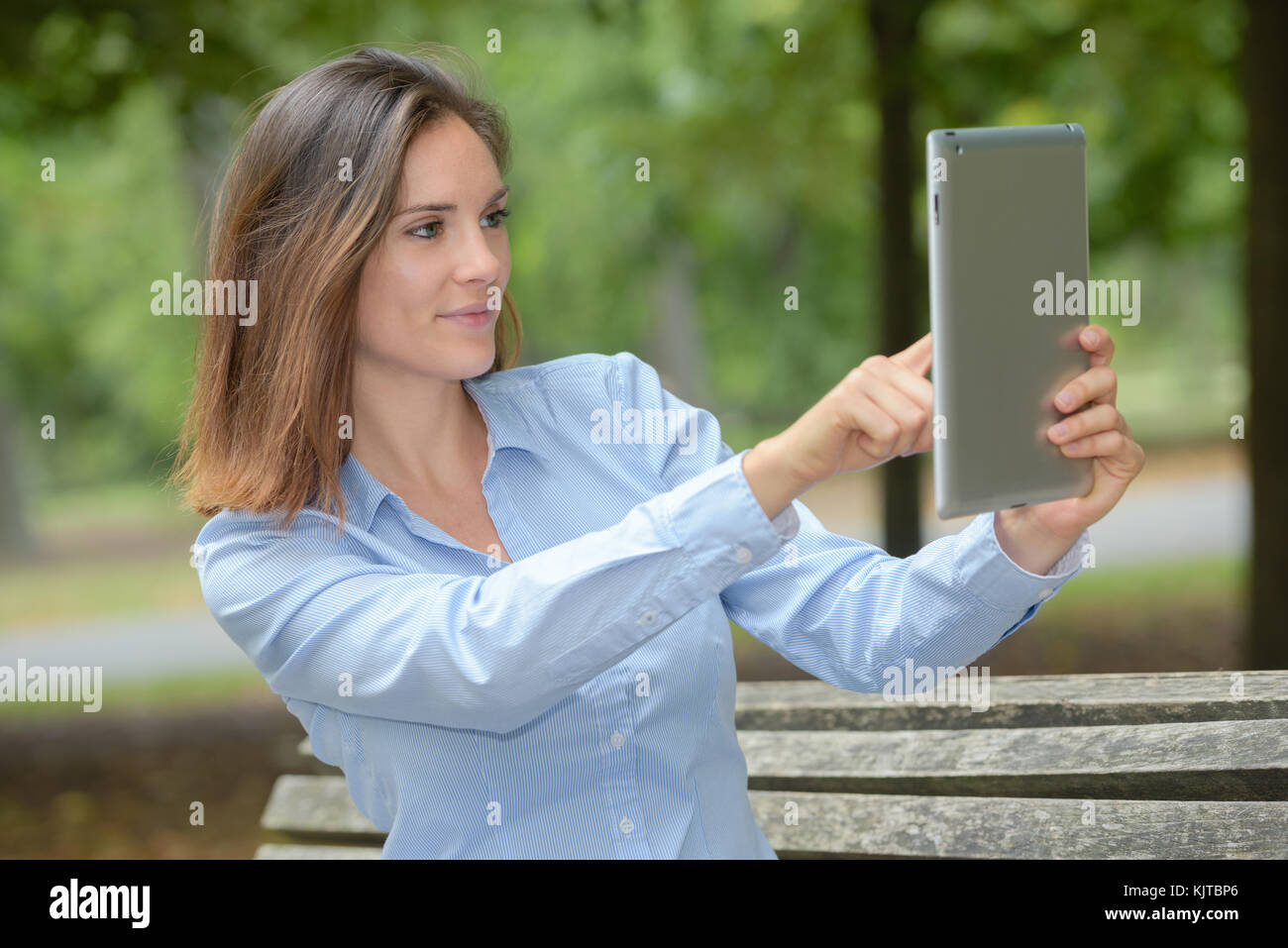 Woman outdoors holding tablet Stock Photo - Alamy