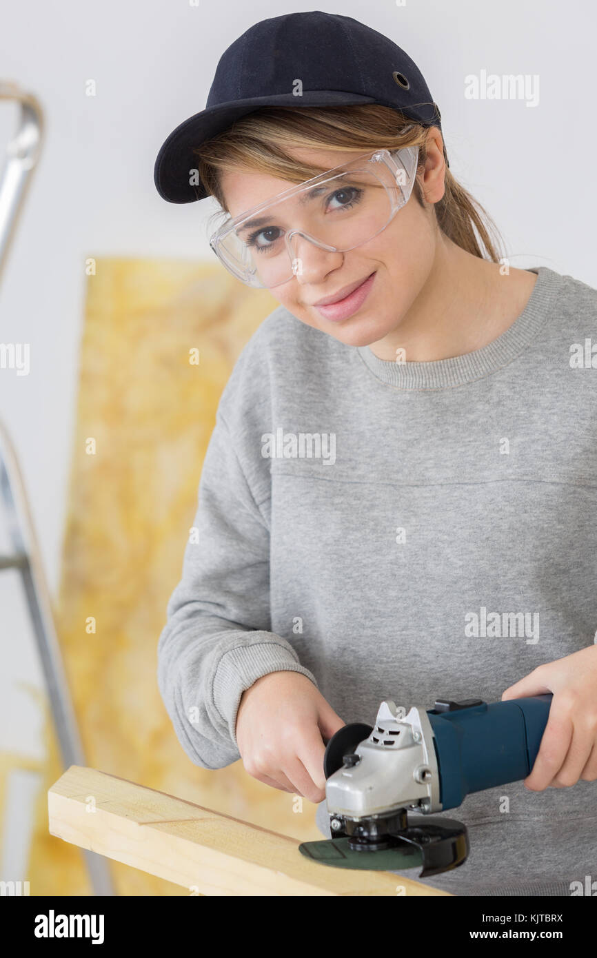 young adult female woodworker using a grinder Stock Photo - Alamy