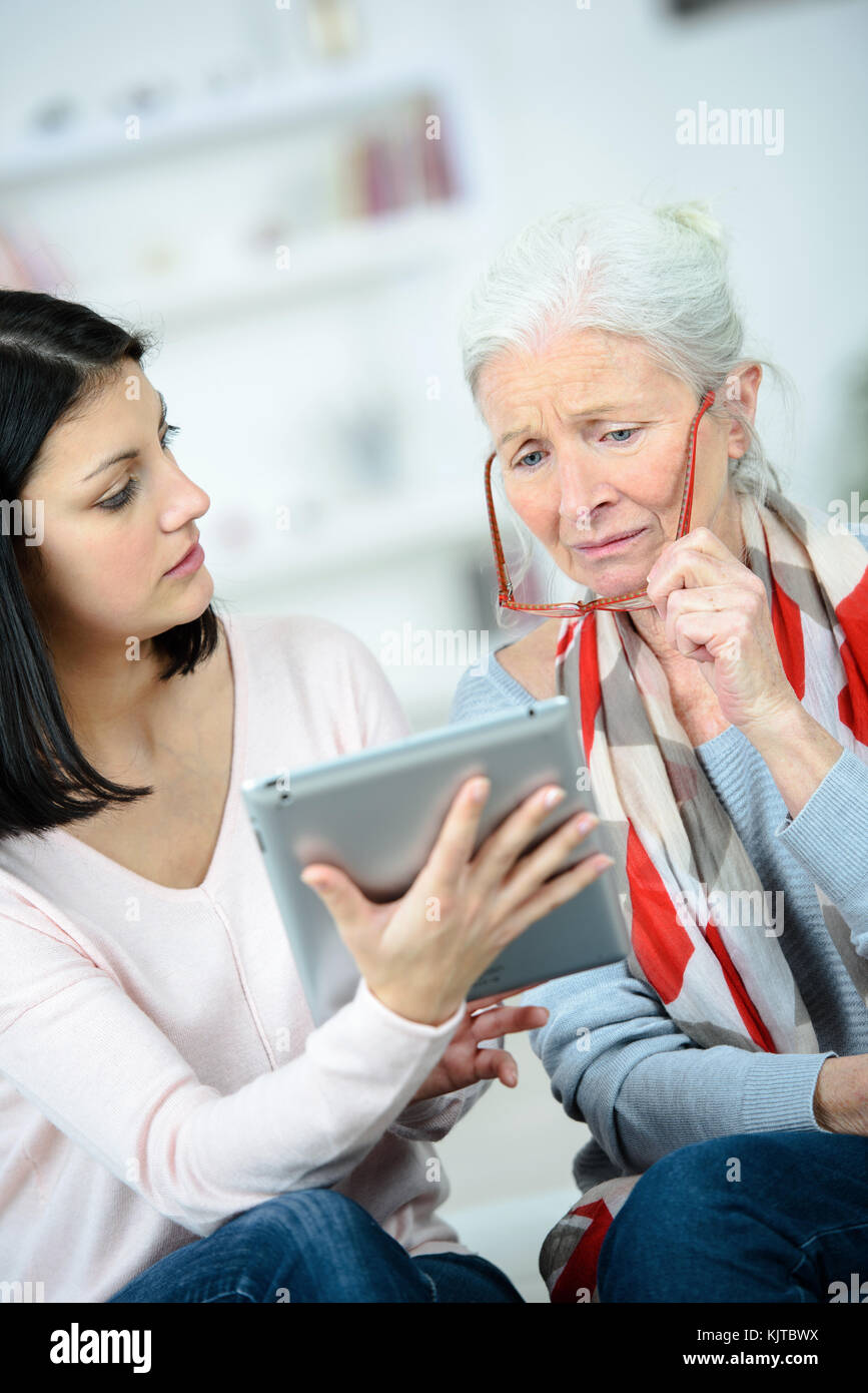 Helping senior woman to read Stock Photo - Alamy
