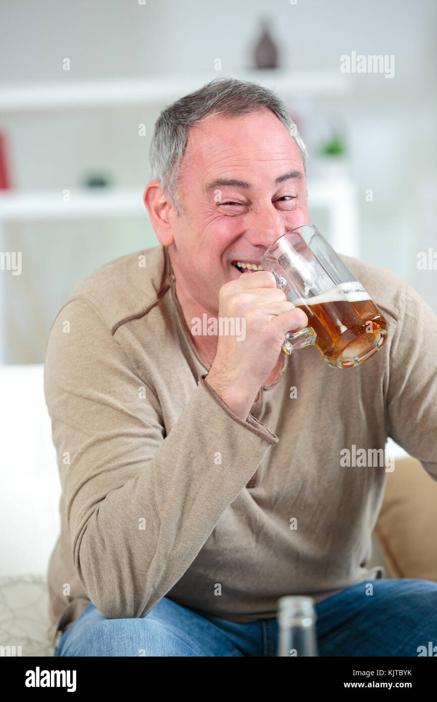 Jolly middle aged man drinking beer Stock Photo - Alamy