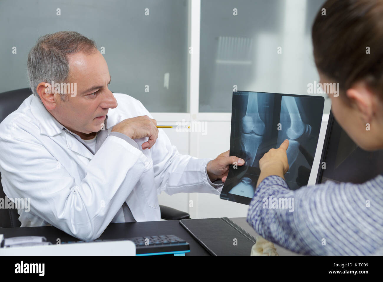 male doctor showing x rays to her patient in office Stock Photo - Alamy