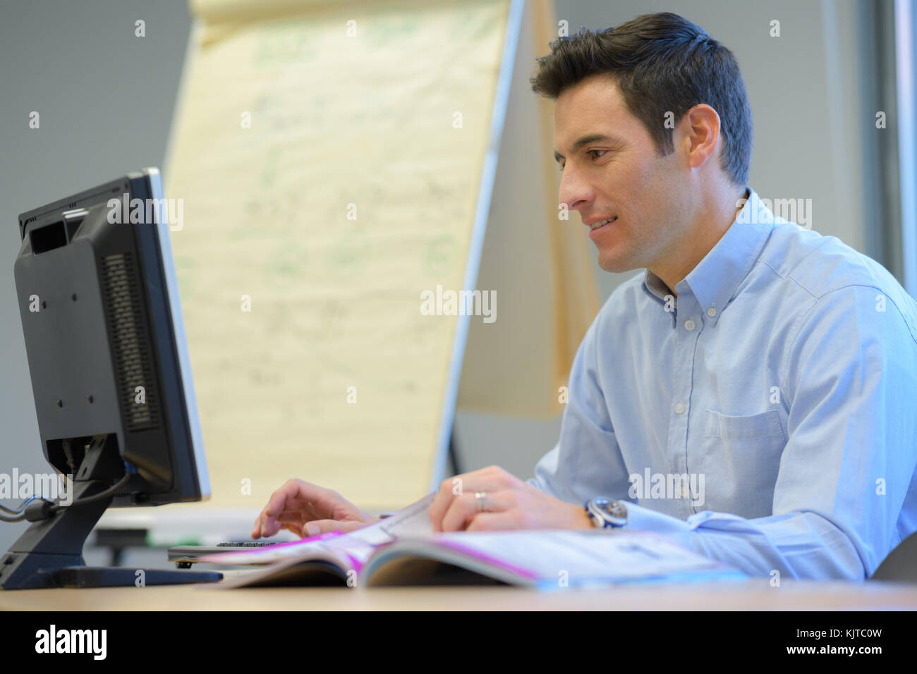 handsome man in an office with a computer at work Stock Photo - Alamy