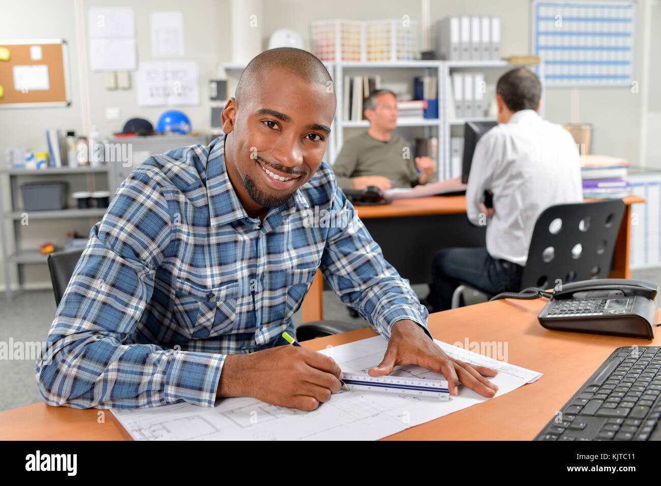 Office worker sat writing at his desk Stock Photo - Alamy