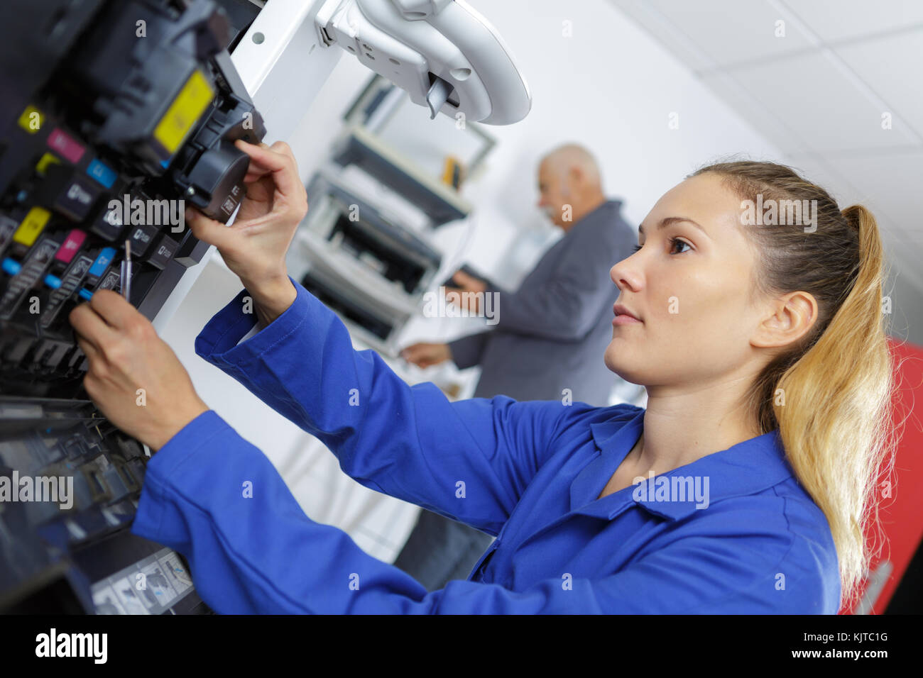 young repairwoman fixing cartridge in printer machine at office Stock ...