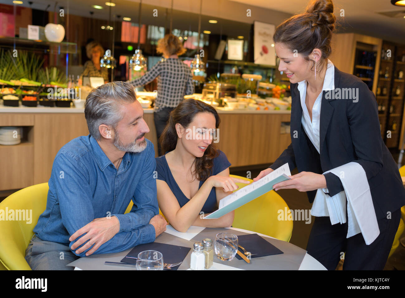 restaurant waitress giving the menu to the customers Stock Photo - Alamy