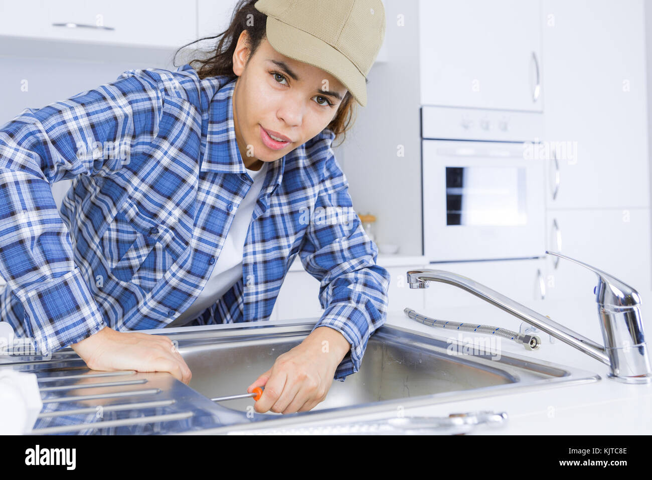 Plumber fitting kitchen sink Stock Photo - Alamy