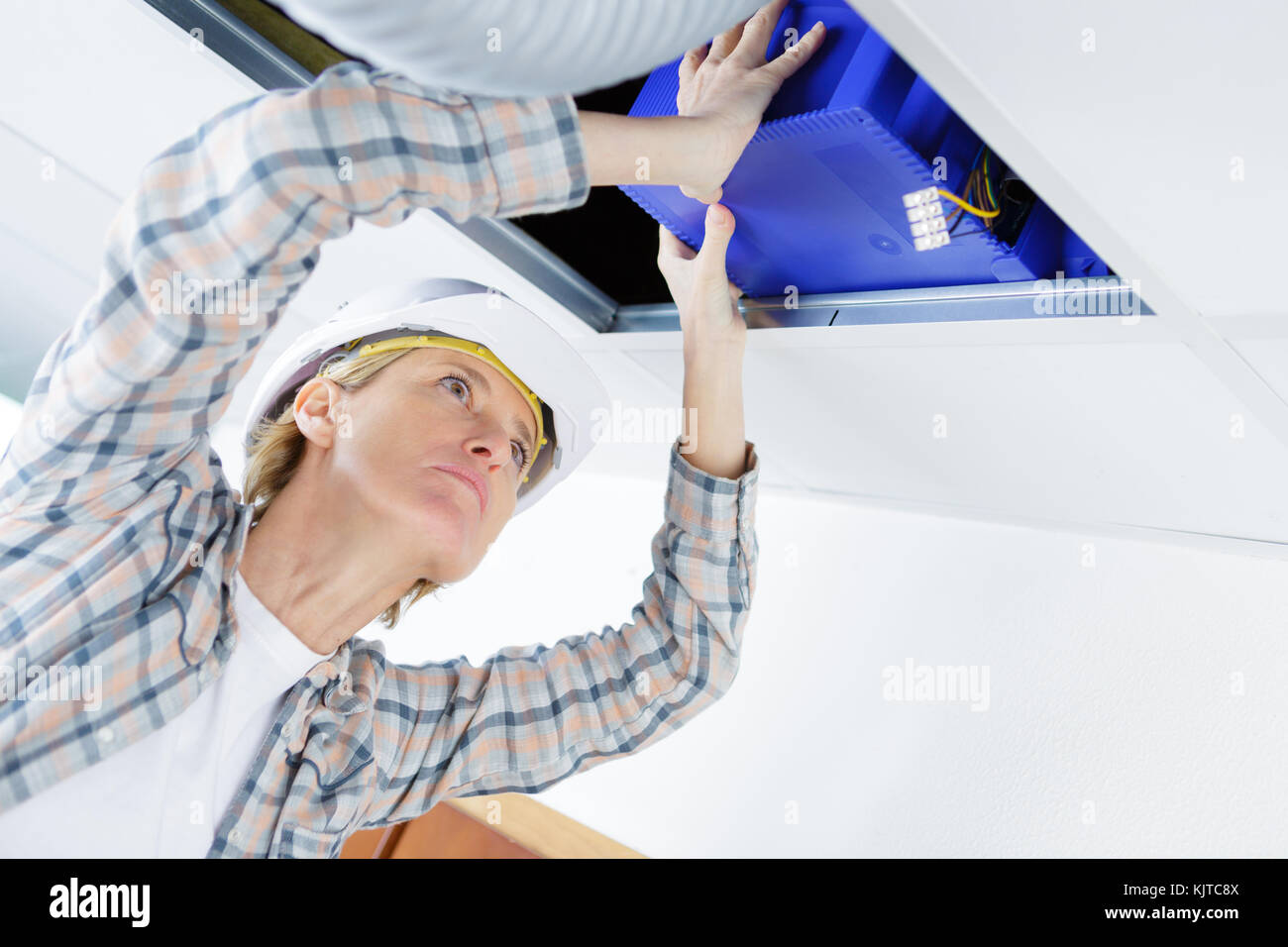 female electrician installing electric device in ceiling Stock Photo ...