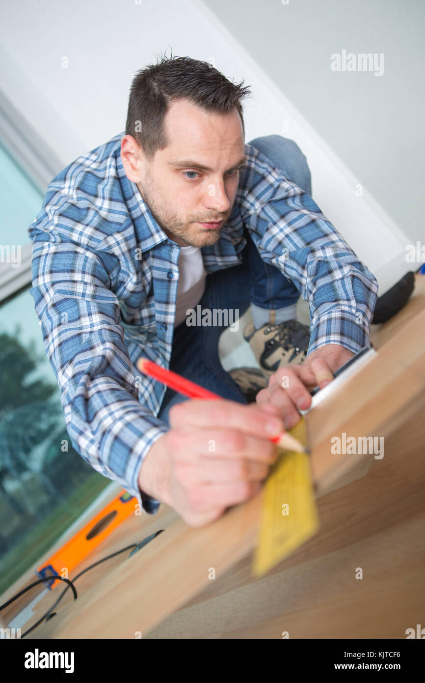 Man measuring floor board Stock Photo - Alamy