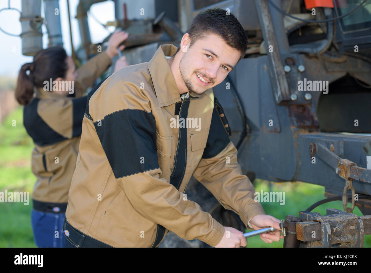 agricultural mechanics checking tractors condition before harvesting ...