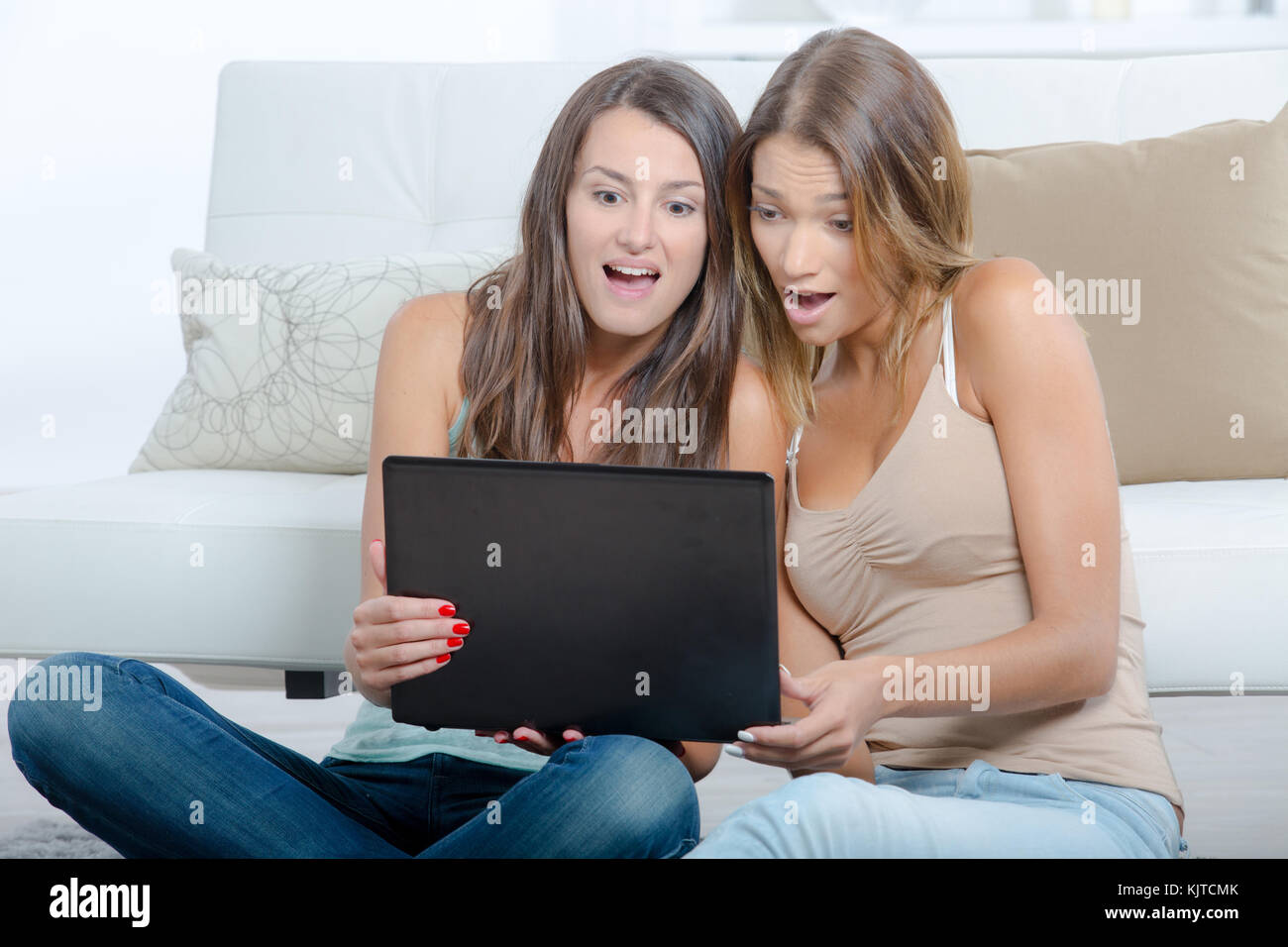 young women using laptop on sofa Stock Photo - Alamy