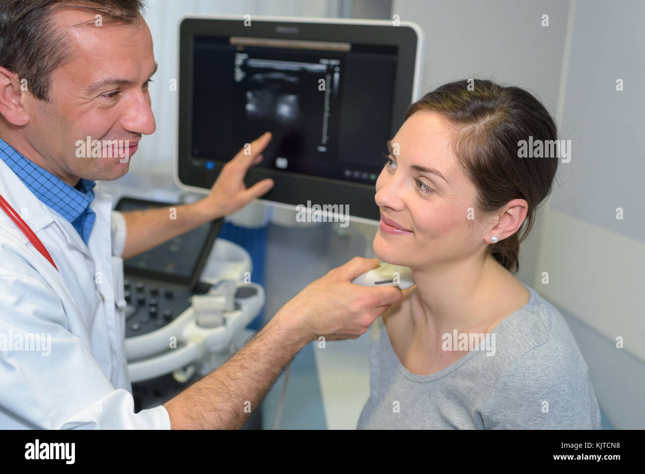 Doctor scanning patient's neck Stock Photo - Alamy