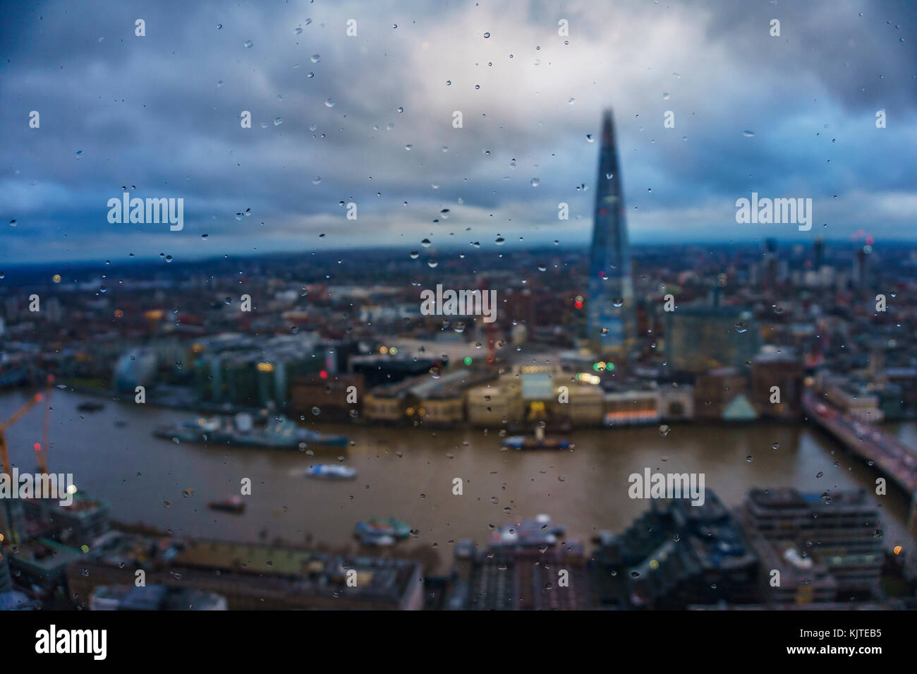 London behind the waterdrops and Thames river at sunset against a ...